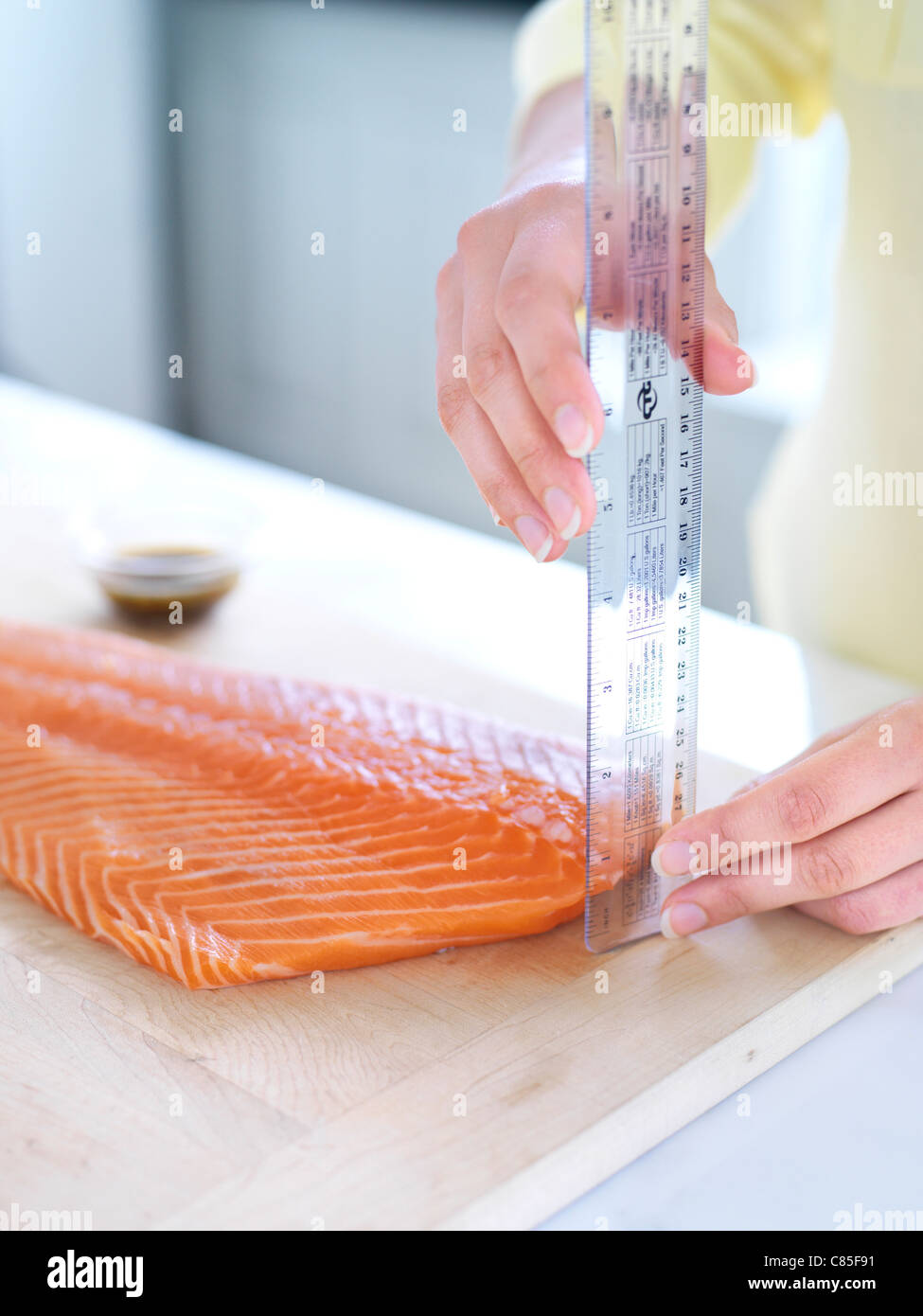 Woman Measuring Salmon to Determine Cooking Time Stock Photo - Alamy