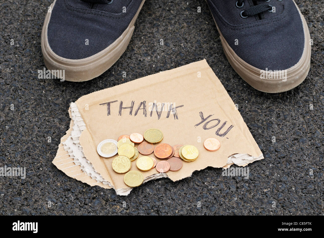 Feet with Spare Change and Thank You Sign Stock Photo - Alamy