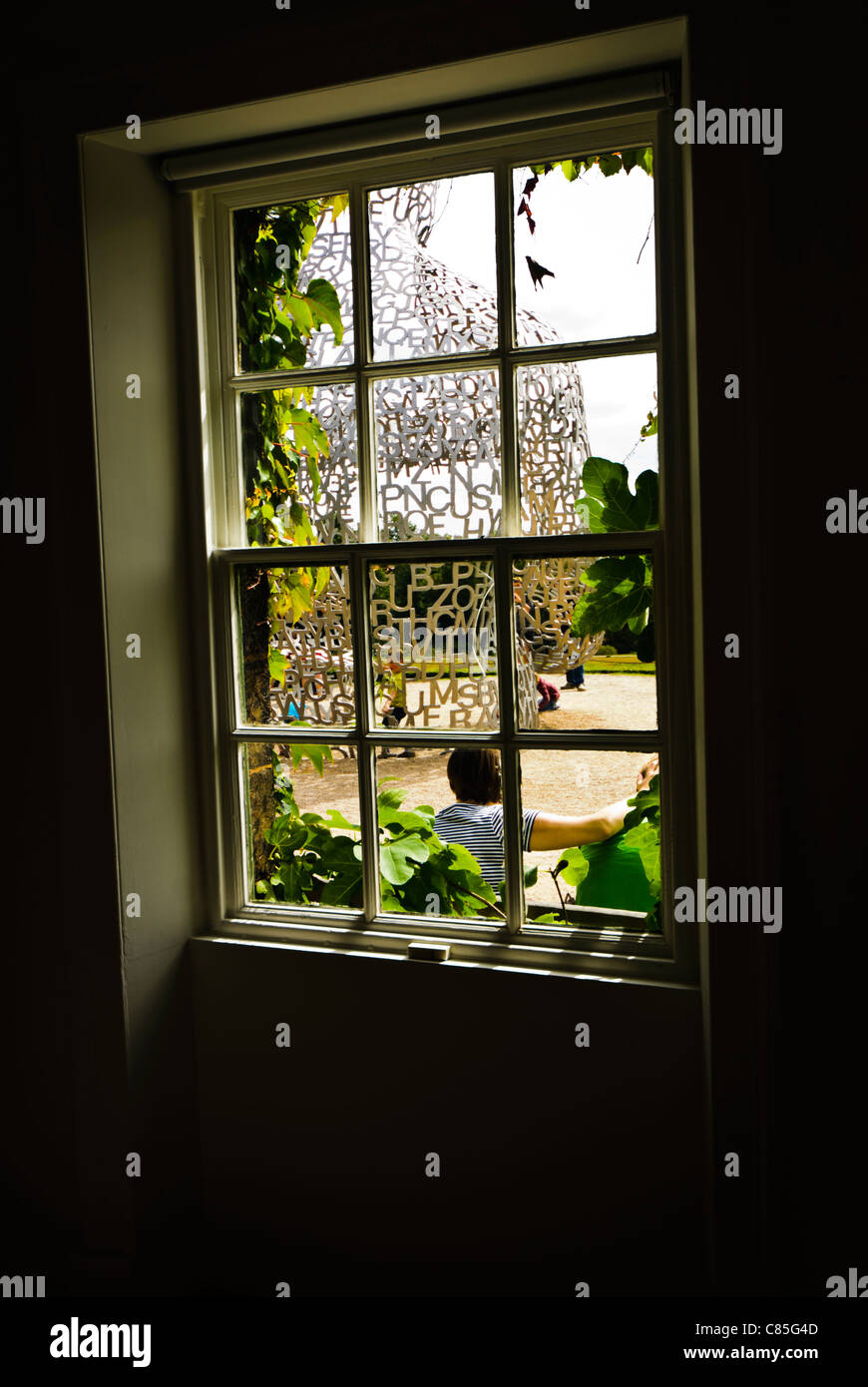 Looking through the window into the garden admiring the artwork Stock ...
