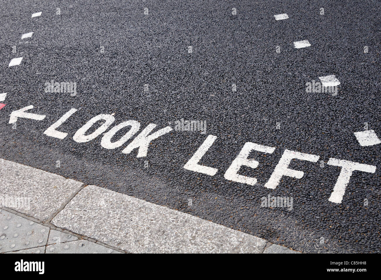 Look Left Warning at Crossing on Road Stock Photo - Alamy