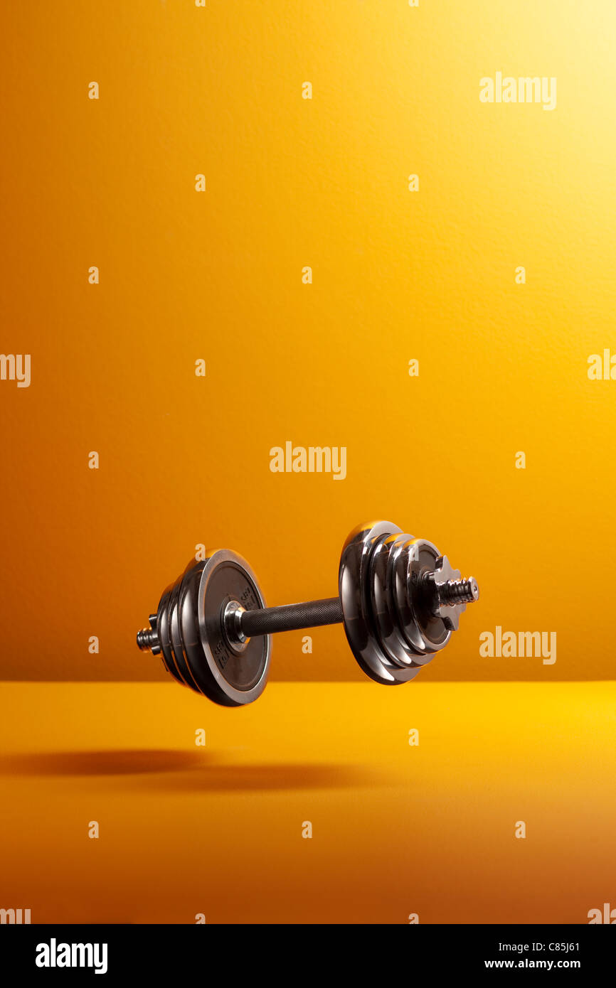Barbells against yellow background Stock Photo - Alamy