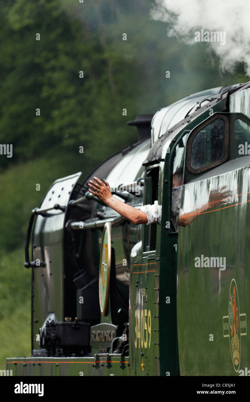 Driver waving goodbye as steam train leaves Horsted Keynes Stock Photo ...
