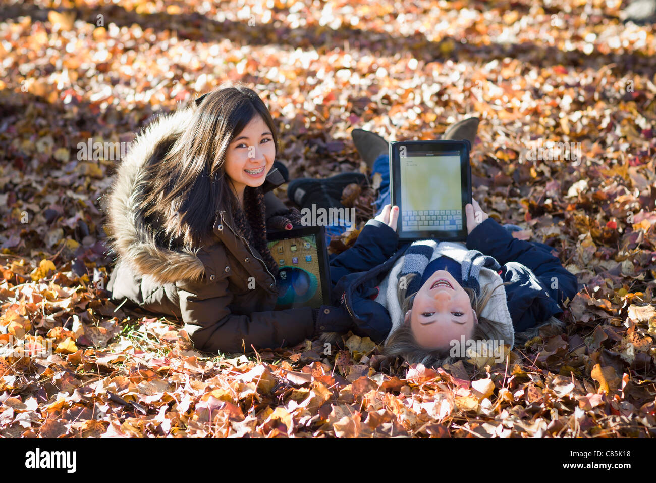 Girls using iPads in Autumn Stock Photo - Alamy