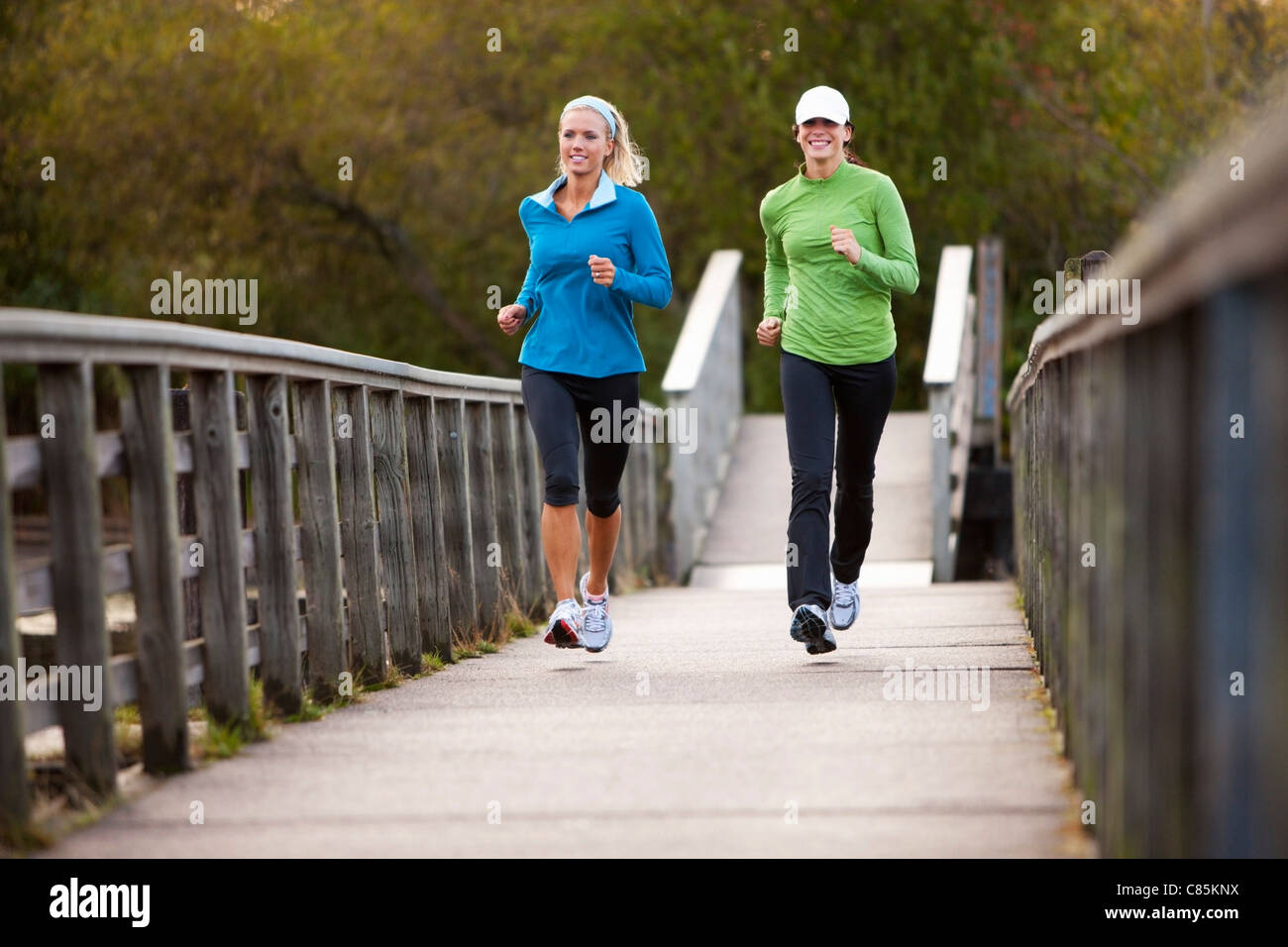 Two Women Jogging through Park Stock Photo - Alamy