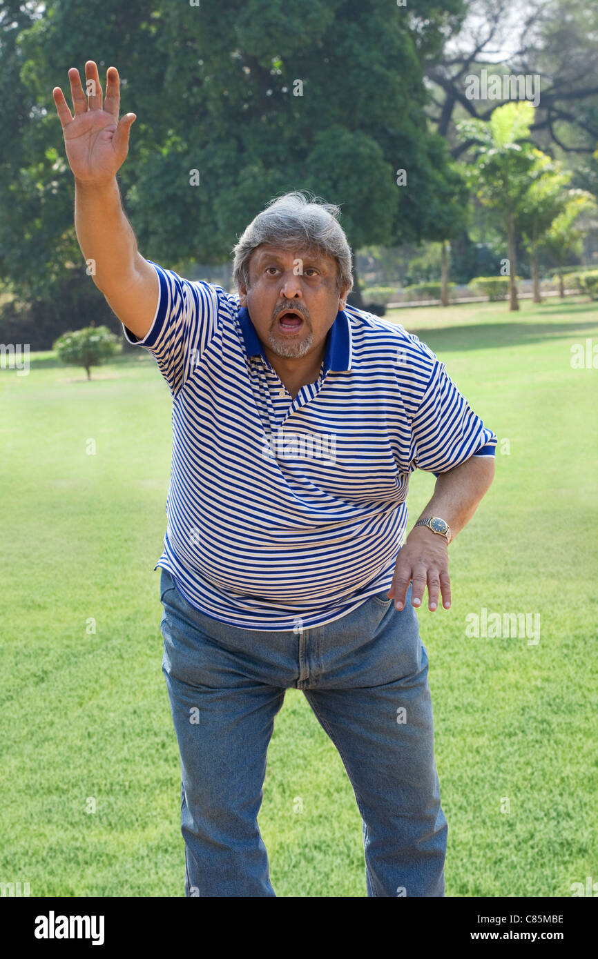 Older man signalling to stop Stock Photo - Alamy