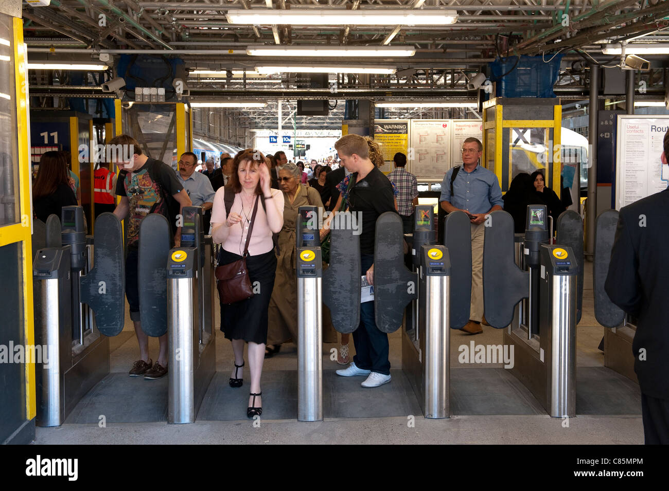 Passengers passing through automatic ticket barriers at a London ...