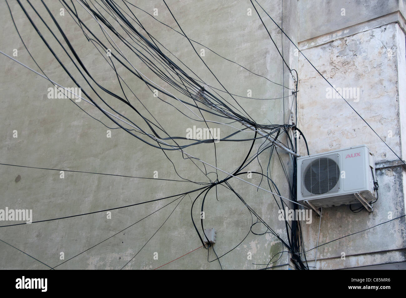 Tangle of electricity wires coming from an air conditioning unit Stock ...