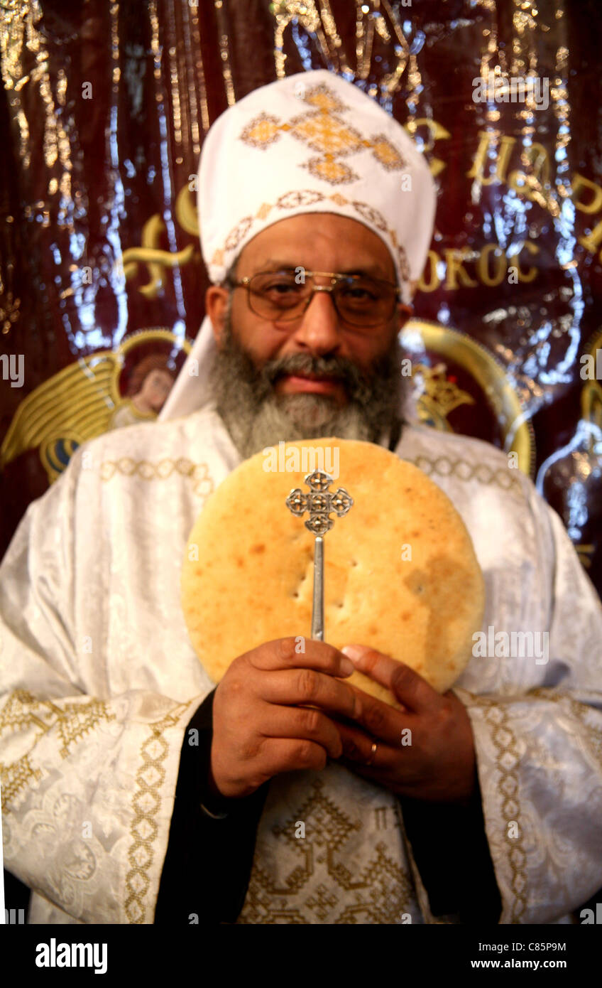 A Coptic priest holding the communion bread for the Eucharist, Church ...