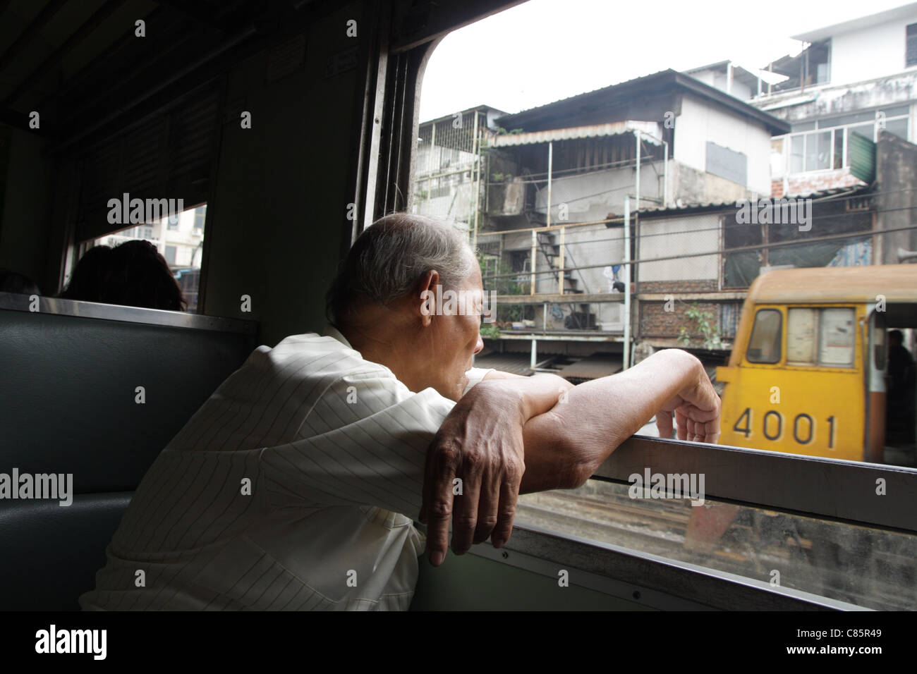 Old man sitting on train in Thailand Stock Photo - Alamy
