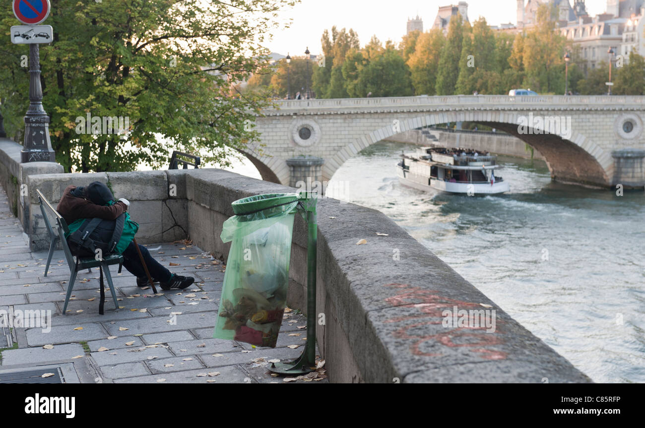 A tired man sleeping by the river Seine in downtown Paris, France Stock ...