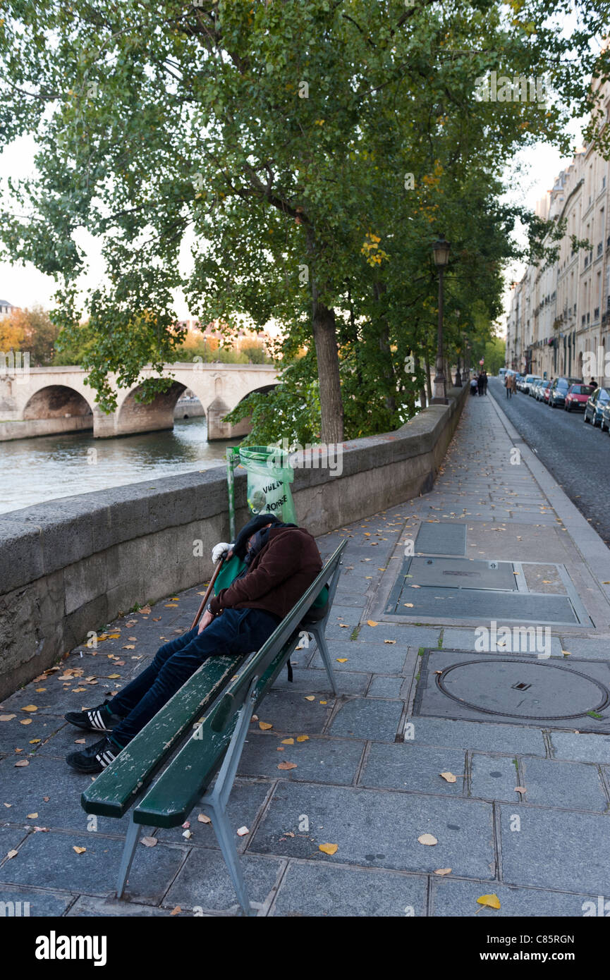 A tired man sleeping by the river Seine in downtown Paris, France Stock ...