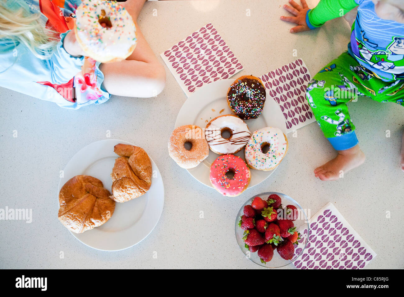 Little kids eating donuts and strawberries Stock Photo - Alamy