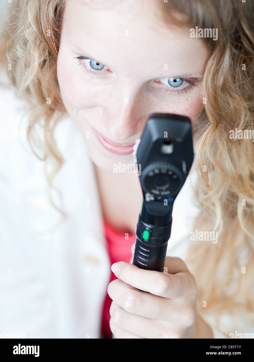 pretty female doctor/optometrist checking your eyes with an ...