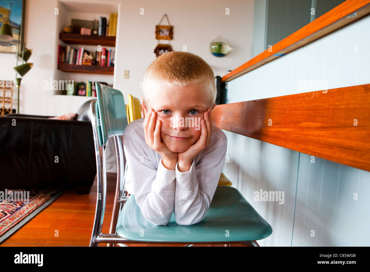 Boy laying across chairs Stock Photo - Alamy