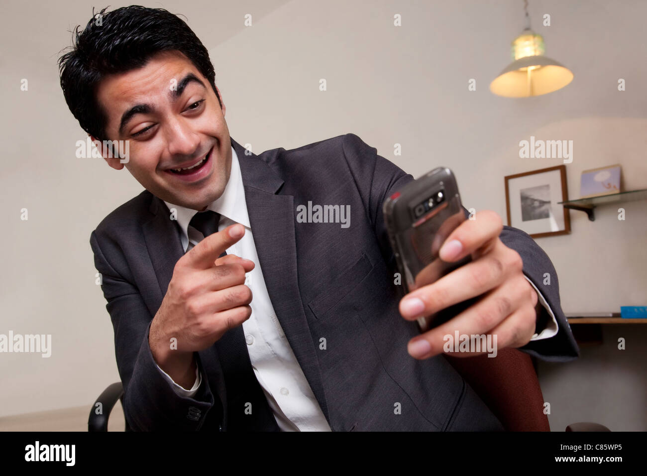 Businessman pointing at his mobile phone Stock Photo - Alamy