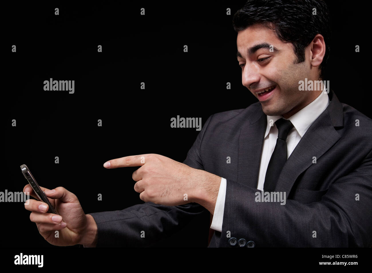 Businessman pointing at his mobile phone Stock Photo - Alamy
