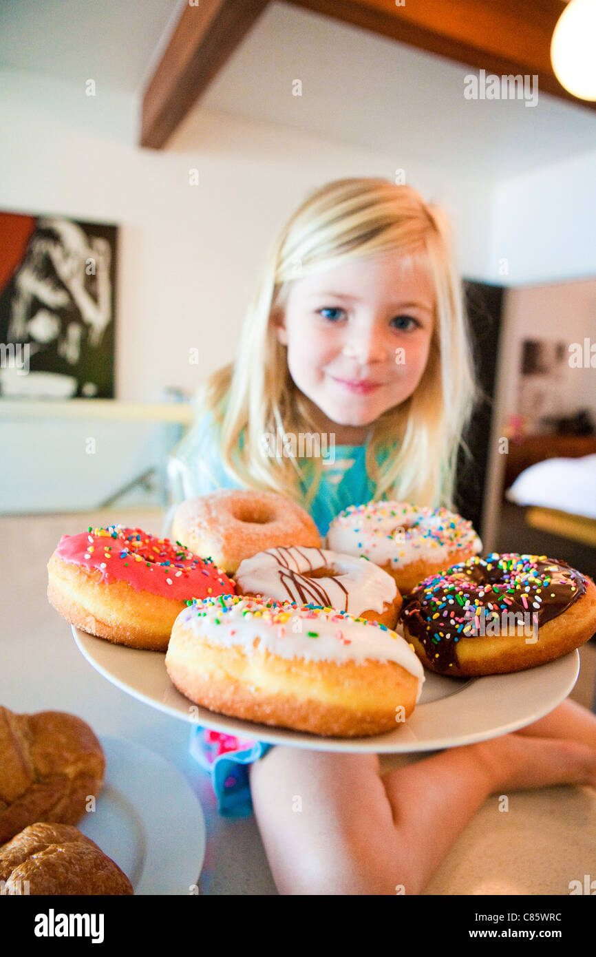 Little girl with a plate of donuts Stock Photo - Alamy