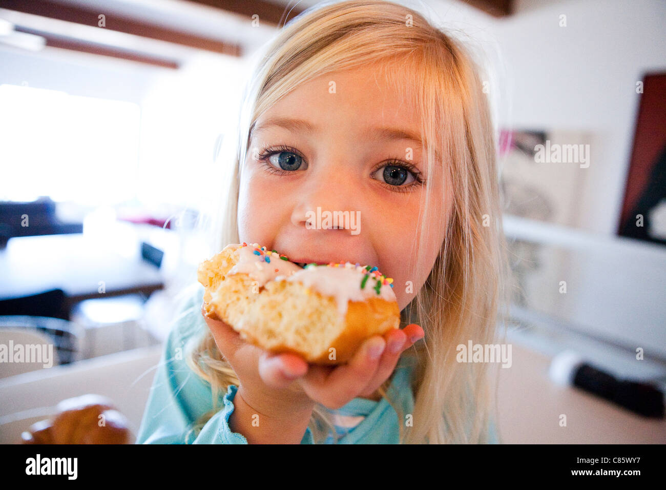 Little girl eating a donut Stock Photo - Alamy