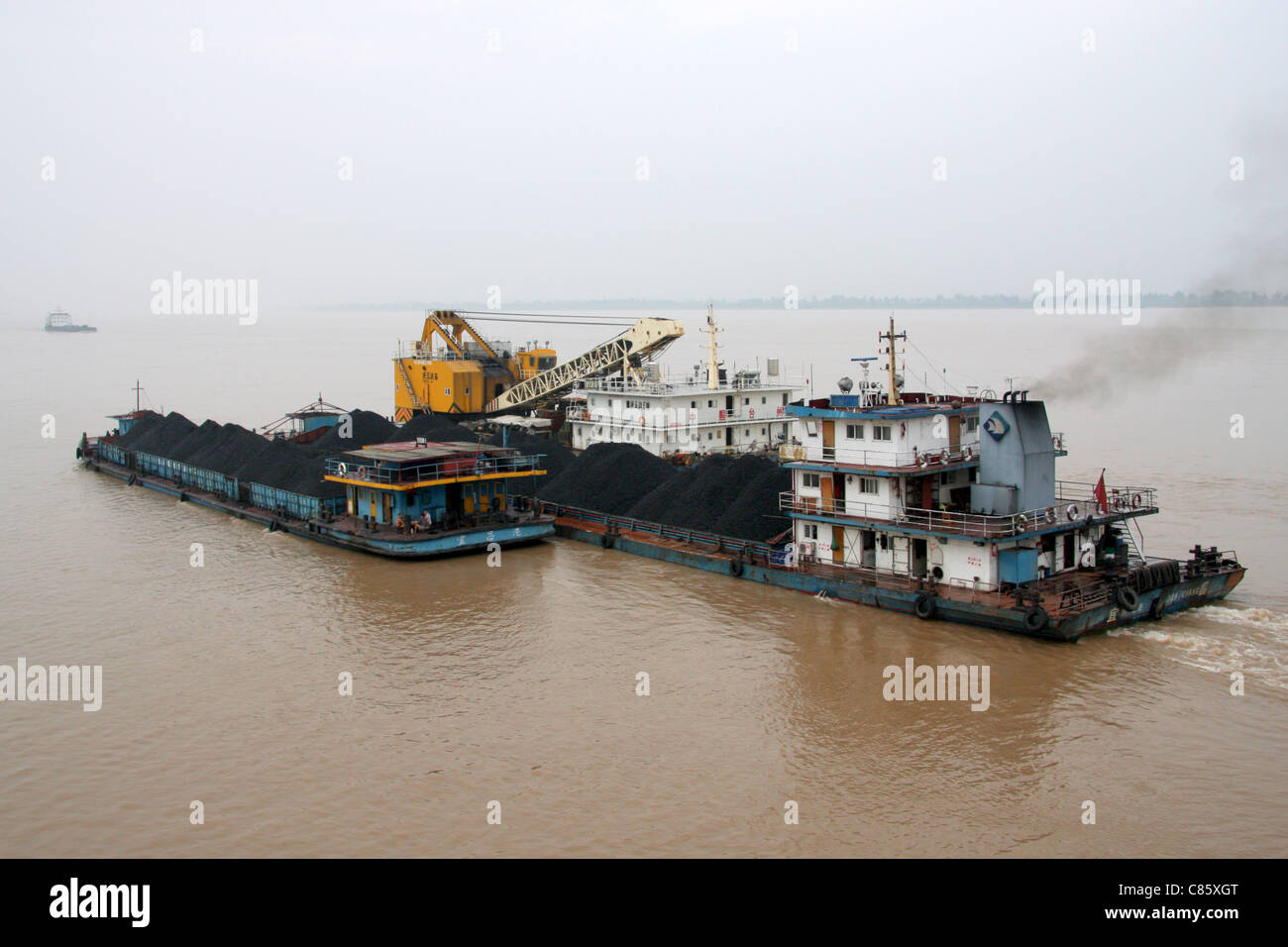 Large shovel and coal boats rafted together and heading upstream on the ...