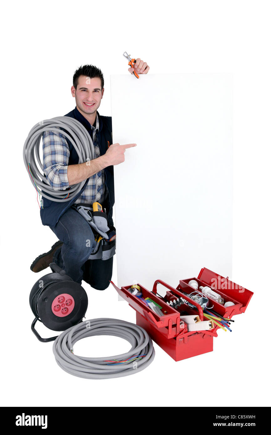 Electrician pointing a white sign for message Stock Photo - Alamy