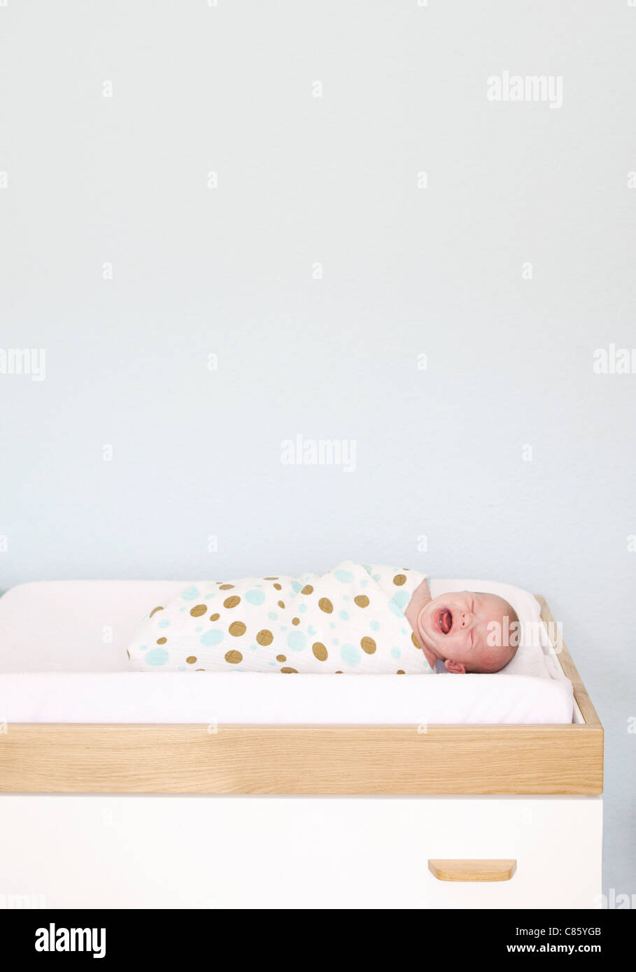 Crying baby on changing table Stock Photo - Alamy