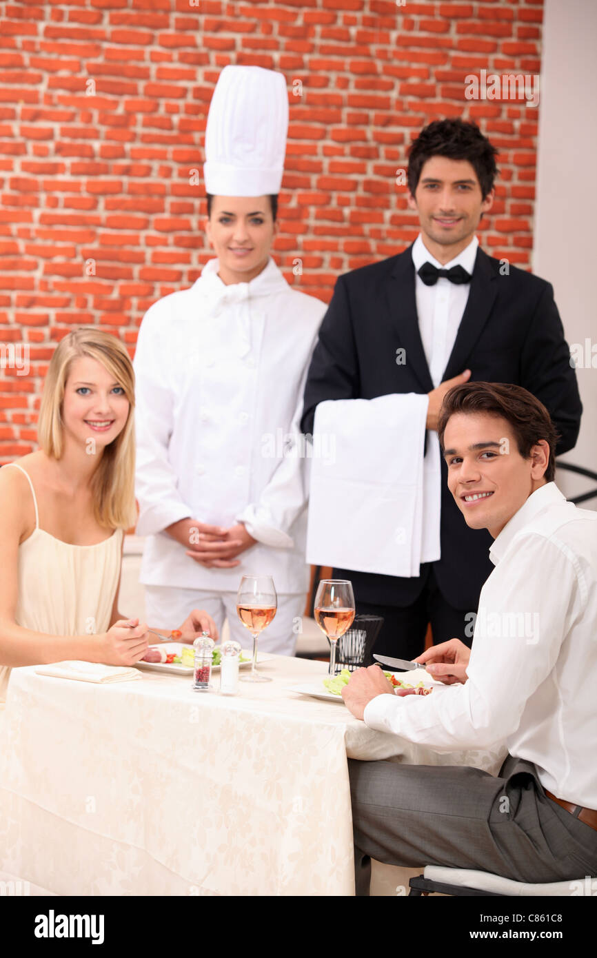A couple being served by a waiter and a chef in a restaurant Stock ...
