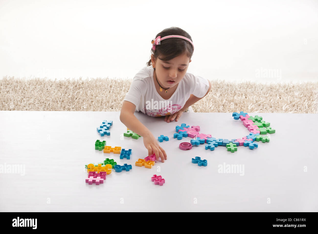 Girl looking for toy pieces Stock Photo - Alamy