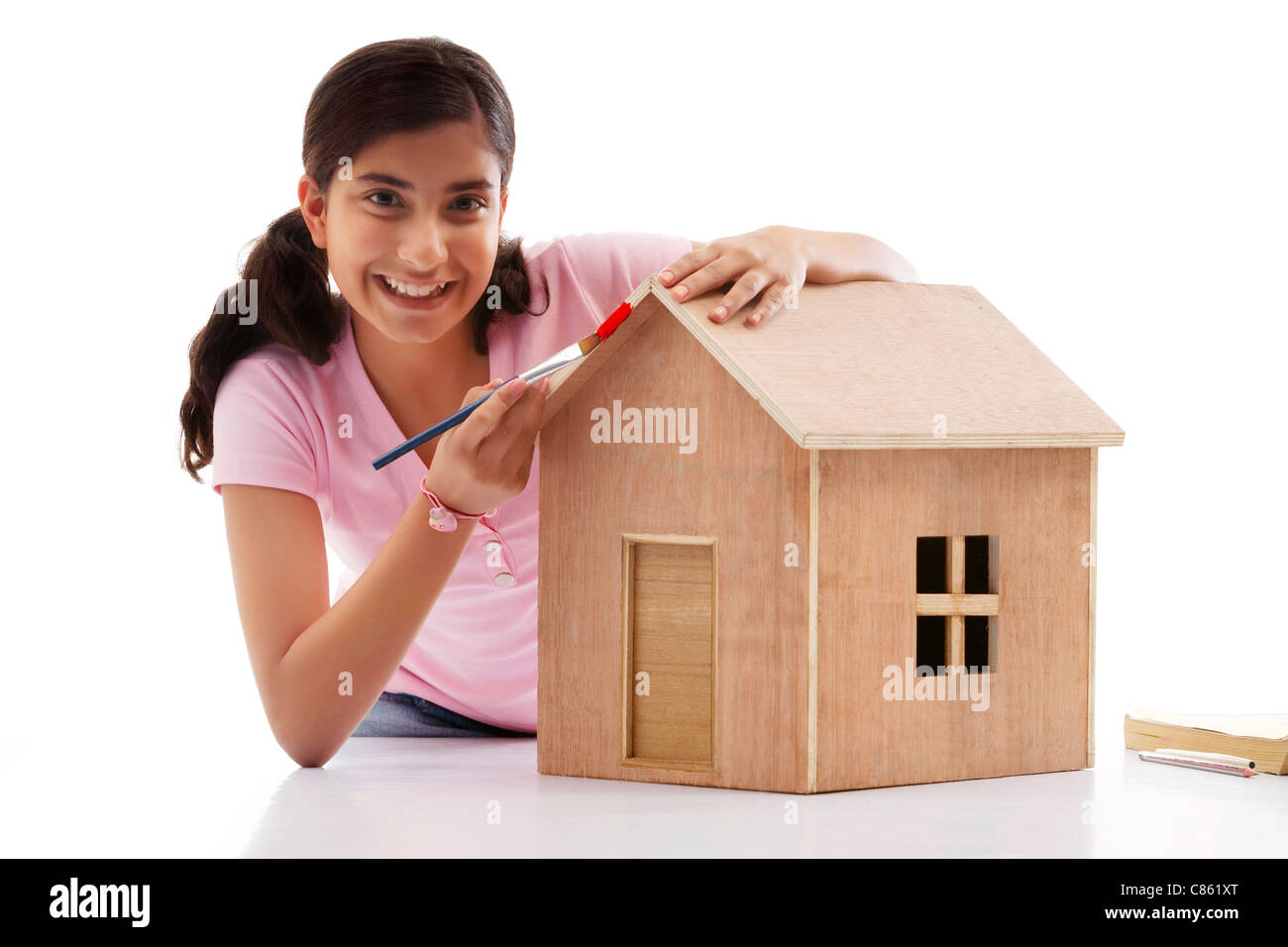 Teenage girl painting a wooden house Stock Photo - Alamy