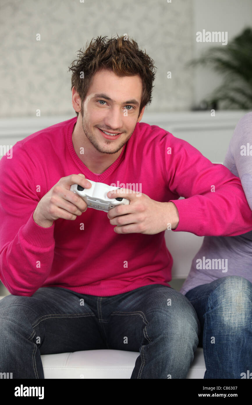 Young man with video game controllers Stock Photo - Alamy