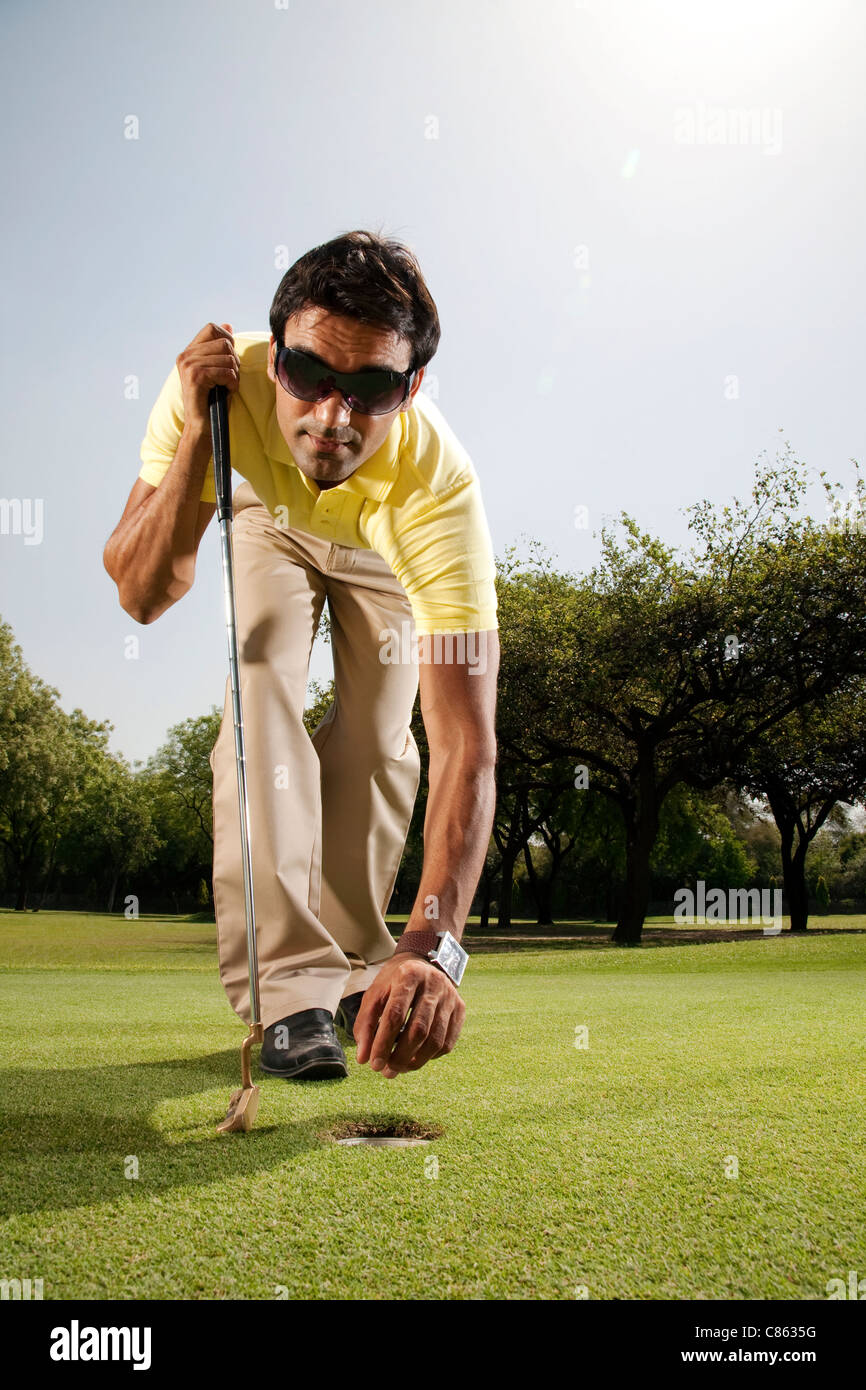 Man reaching for the golf ball Stock Photo - Alamy