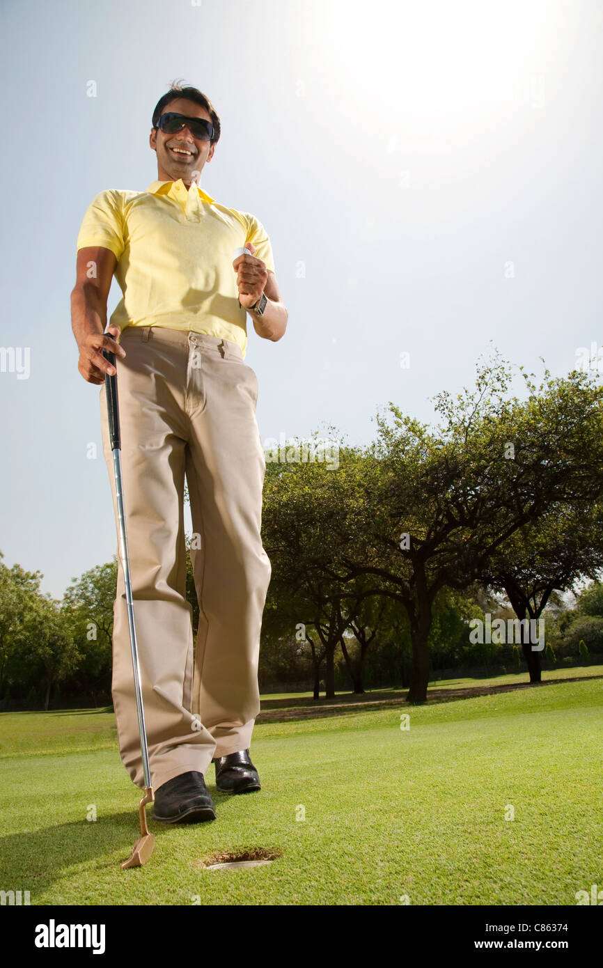 Man with a golf club and golf ball Stock Photo - Alamy