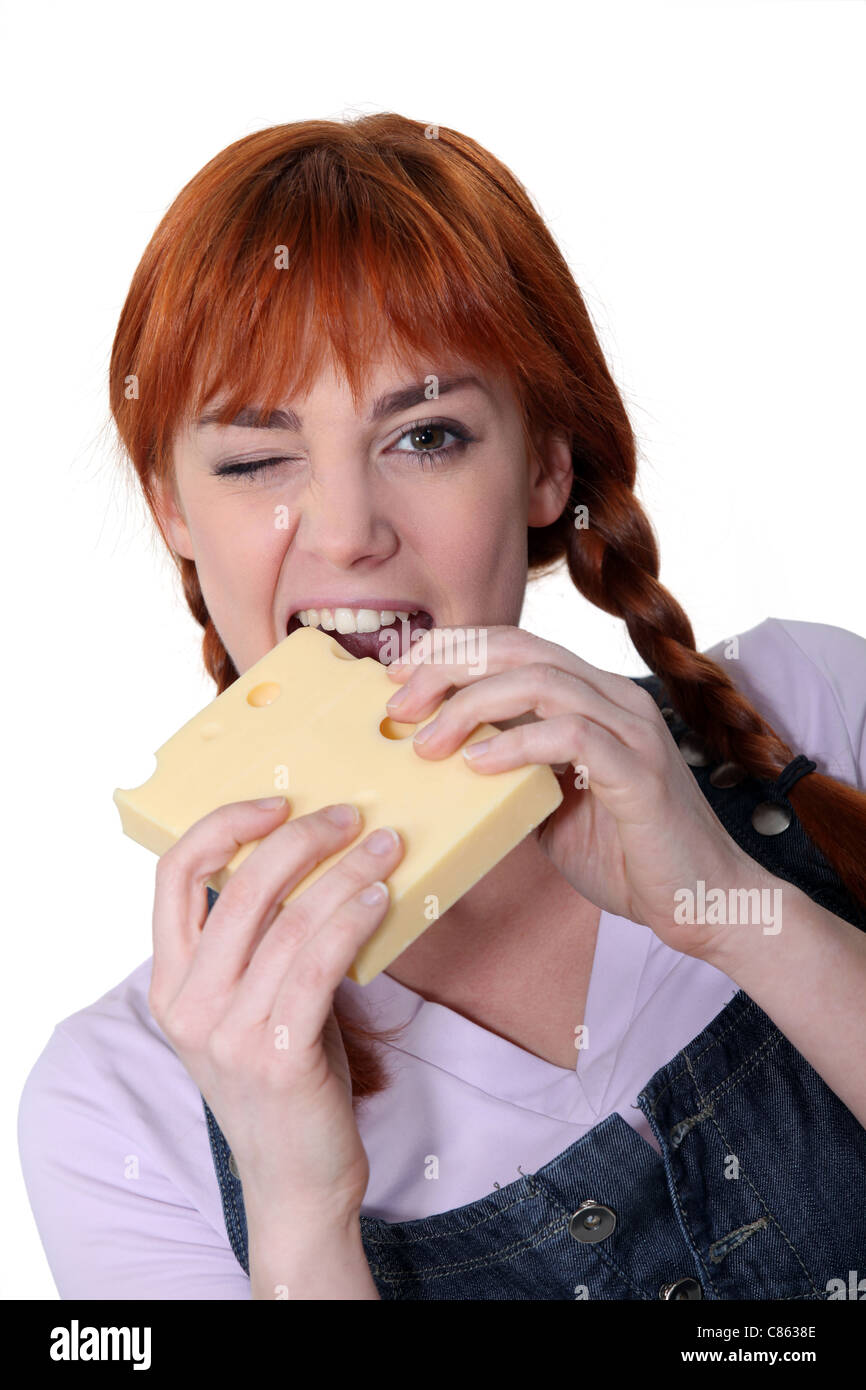 Woman biting into block of cheese Stock Photo - Alamy