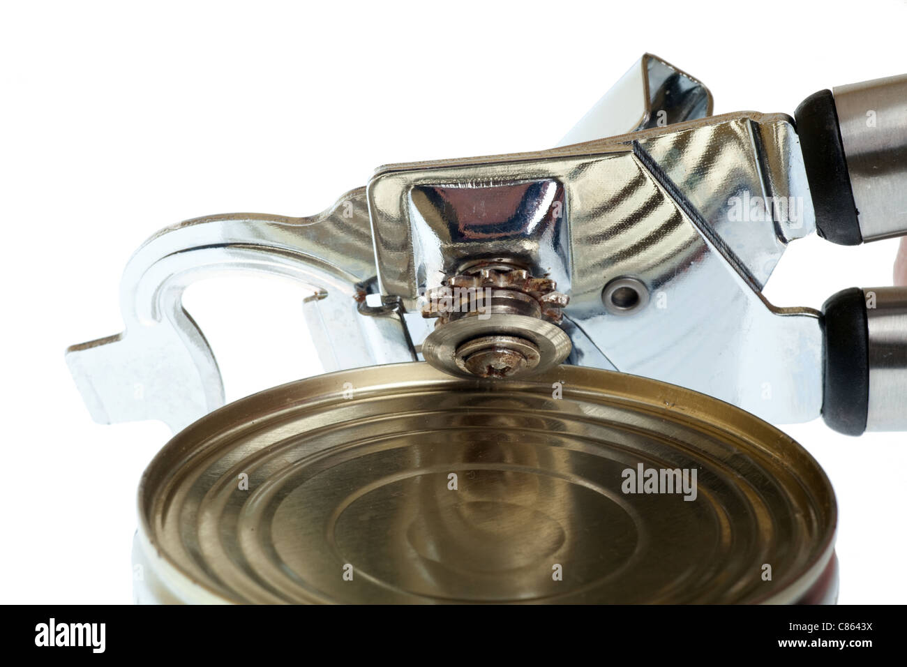 Tin opener opening a can of food isolated on white Stock Photo - Alamy