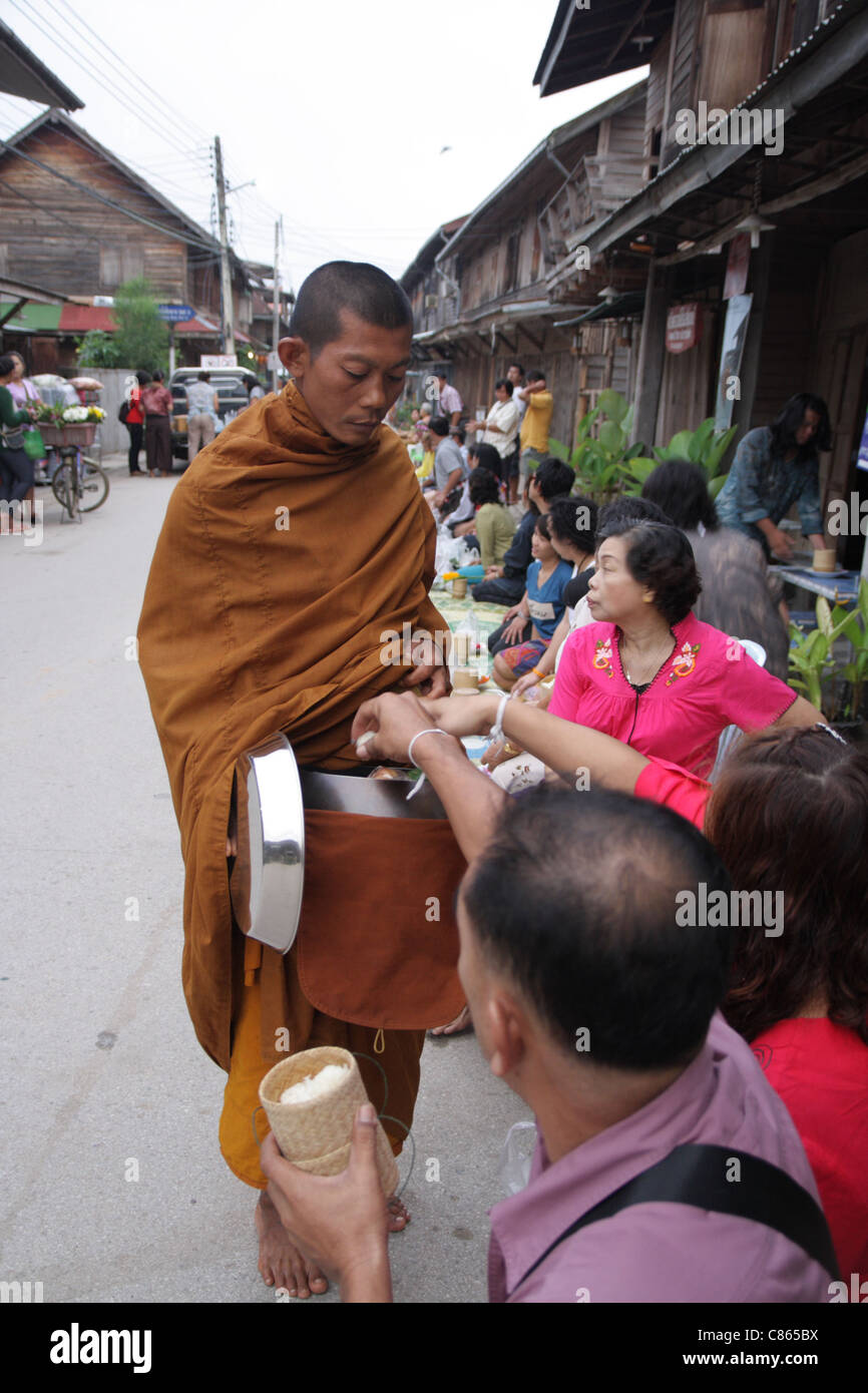 People give food offerings food to a Buddhist monk at Chiangkhan ...