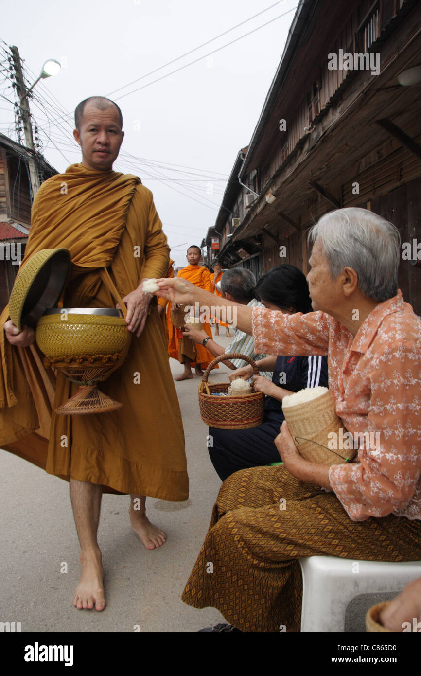 People give food offerings food to a Buddhist monk at Chiangkhan ...
