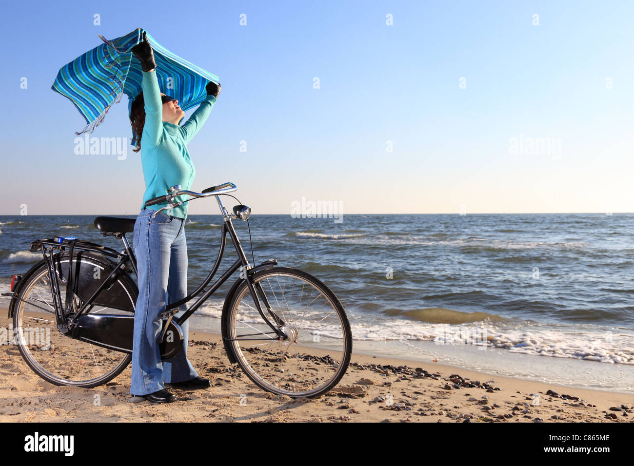 woman in blue, bike and shawl at sea shore Stock Photo - Alamy