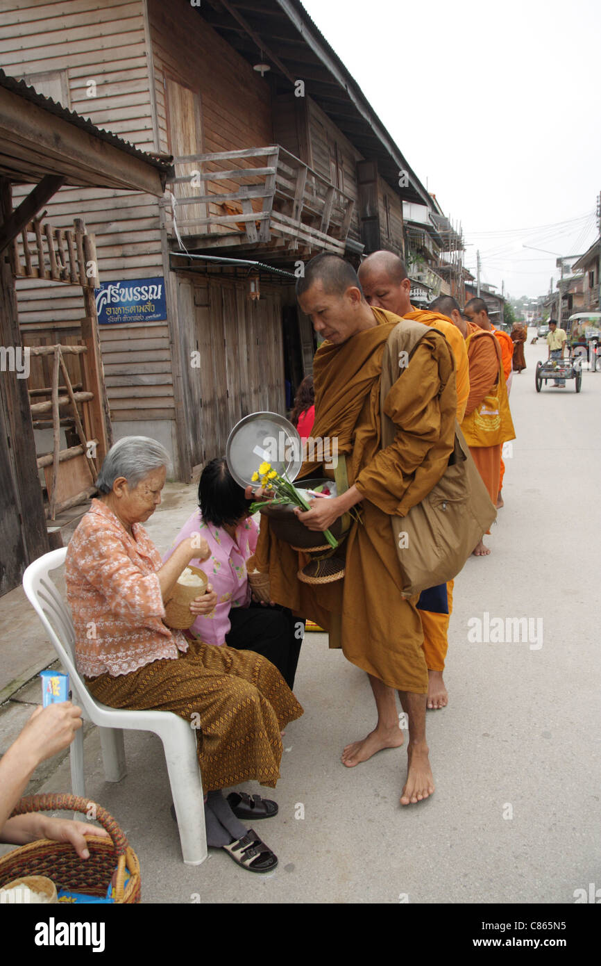 People give food offerings food to a Buddhist monk at Chiangkhan ...