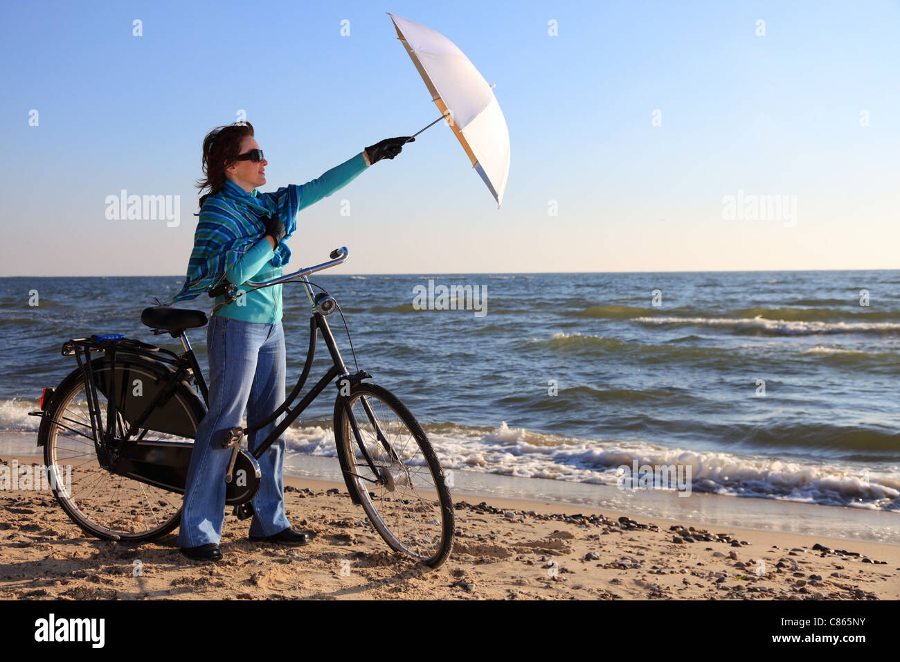 woman in blue, bike and shawl at sea shore Stock Photo - Alamy