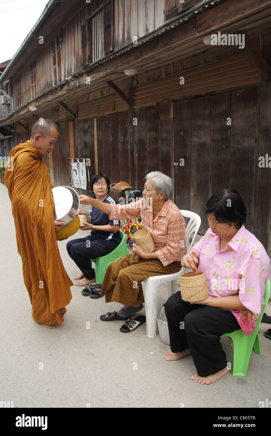 People give food offerings food to a Buddhist monk at Chiangkhan ...