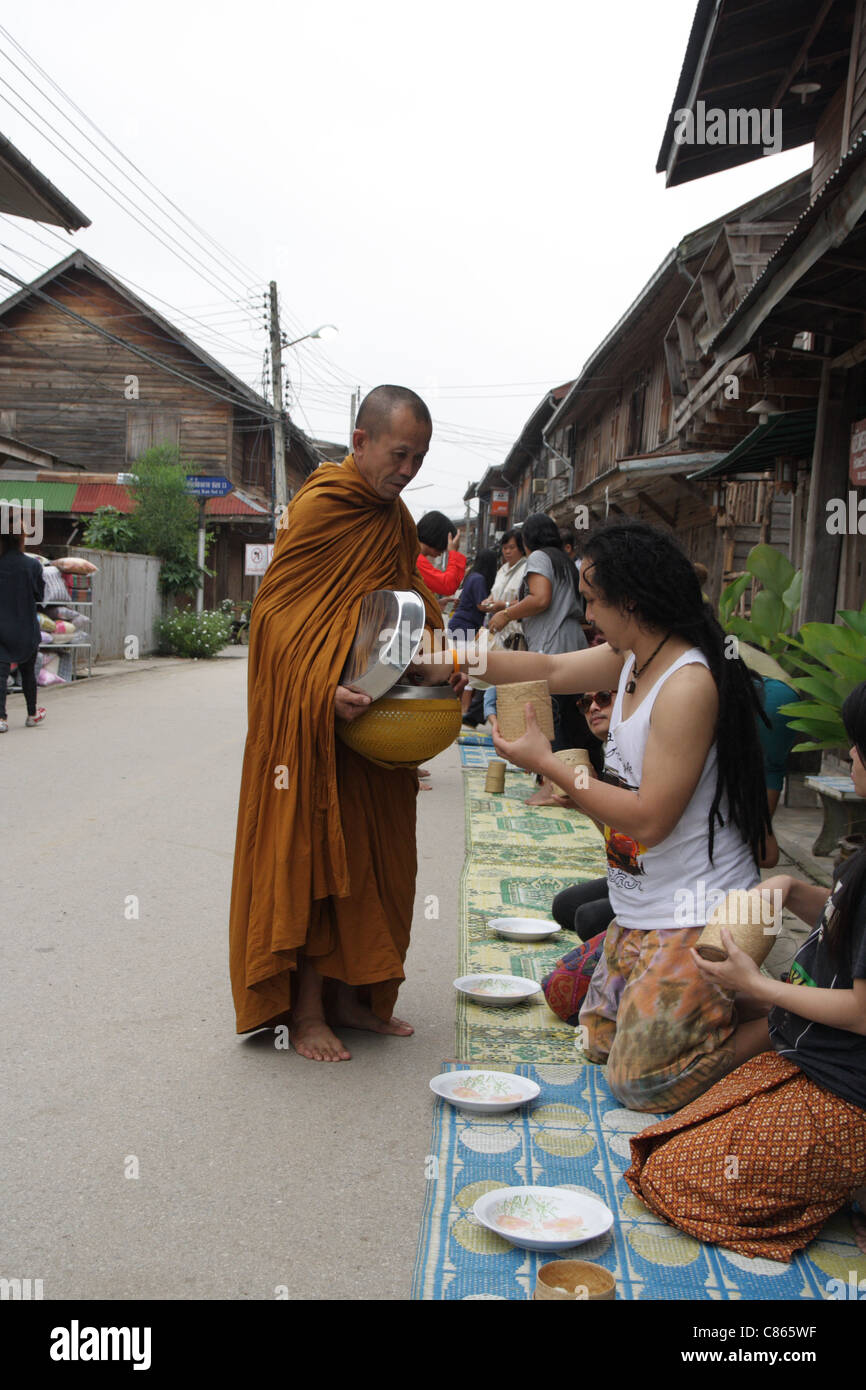 People give food offerings food to a Buddhist monk at Chiangkhan ...