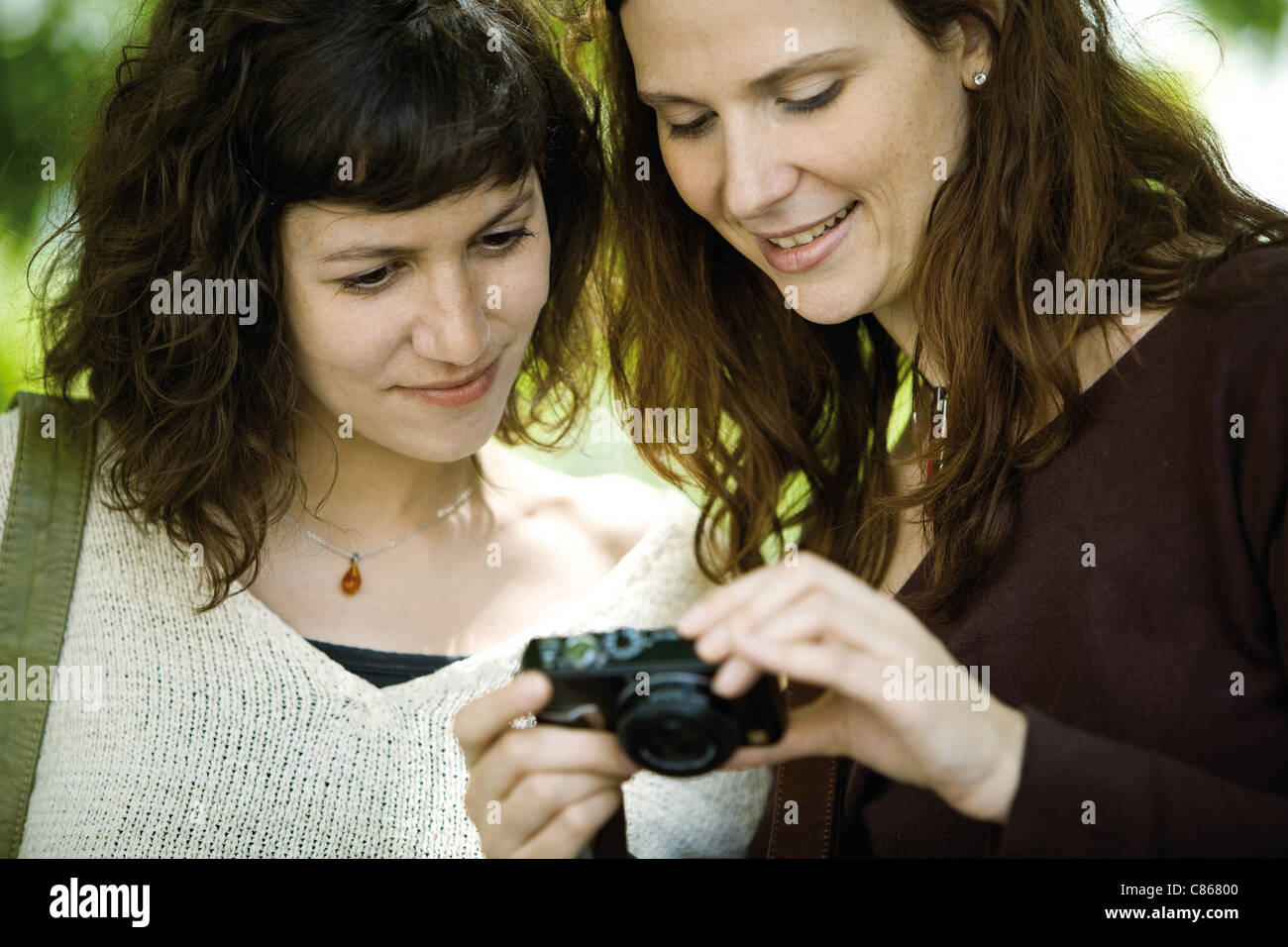 Woman showing digital camera to friend Stock Photo - Alamy