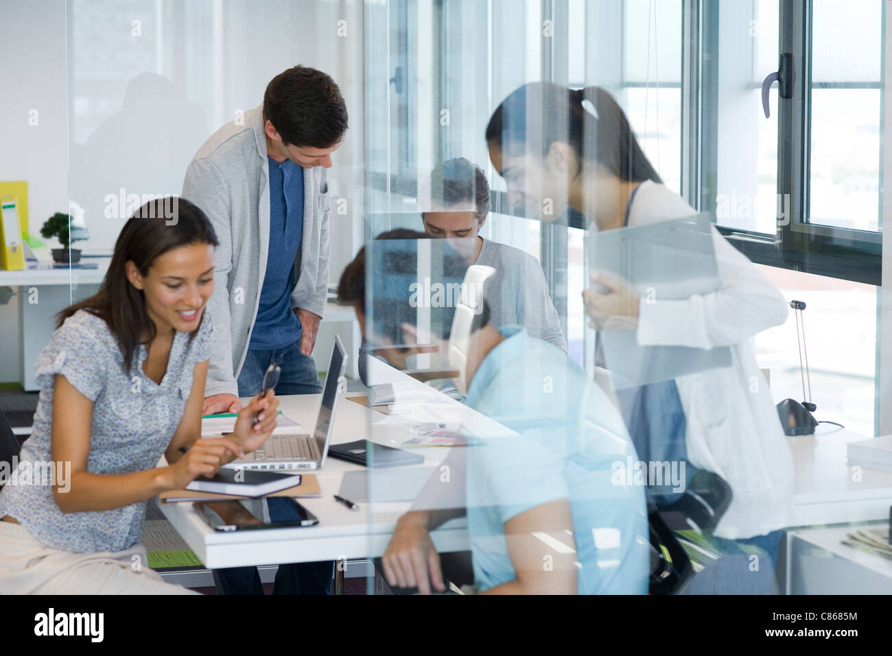 Colleagues collaborating in office Stock Photo - Alamy