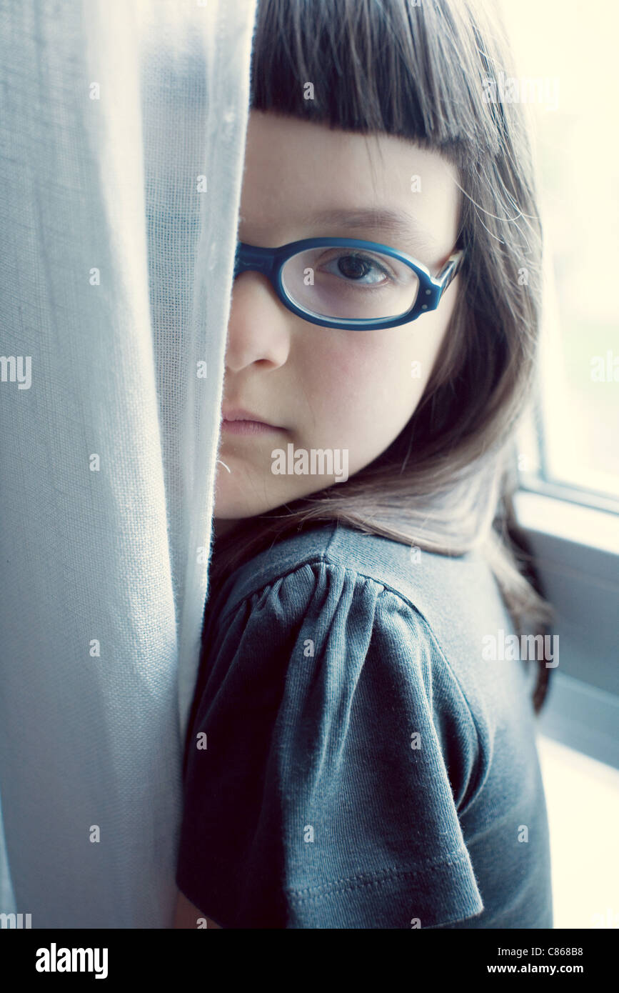 Girl hiding behind curtain Stock Photo - Alamy
