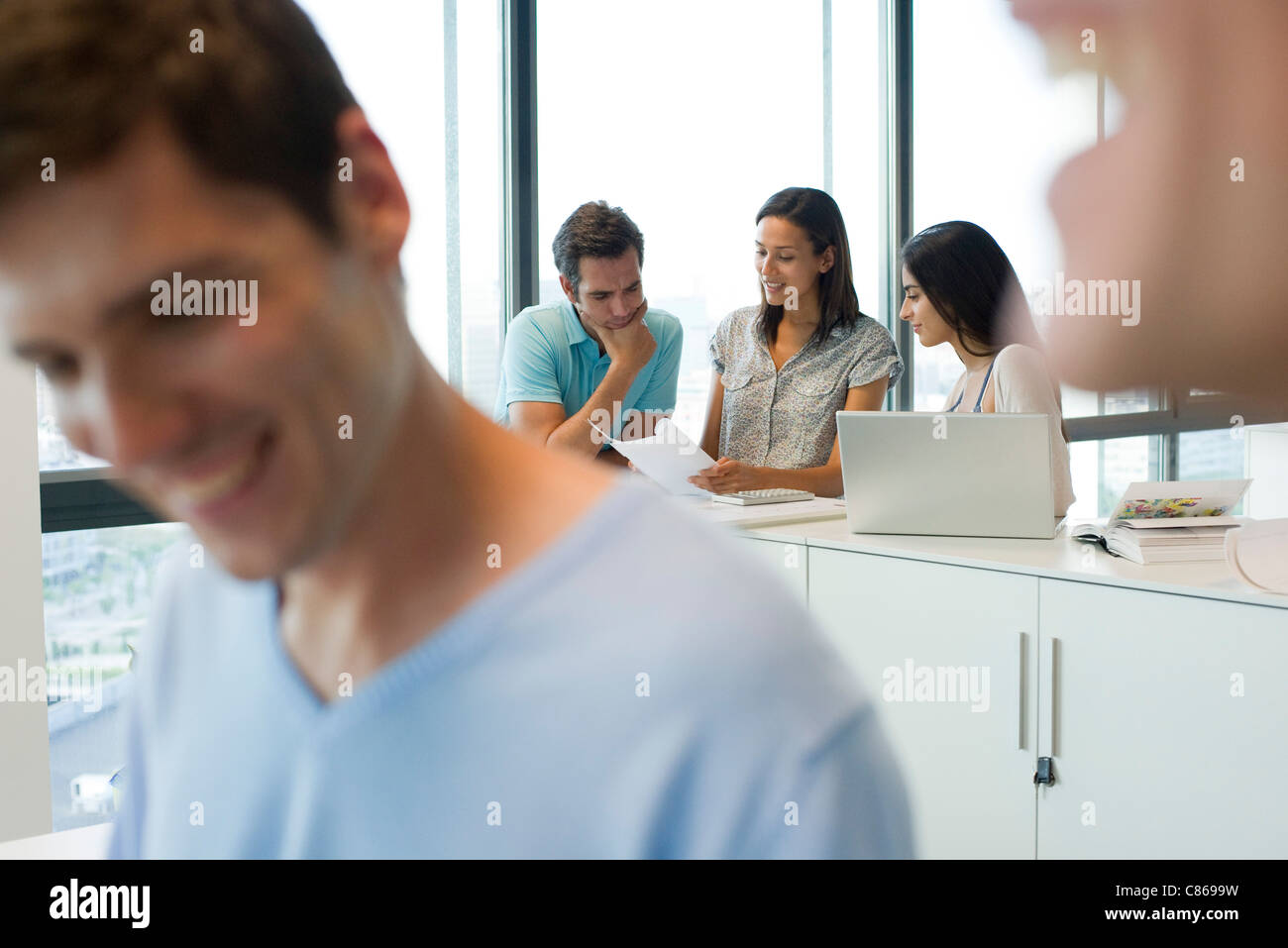Colleagues collaborating in office Stock Photo - Alamy