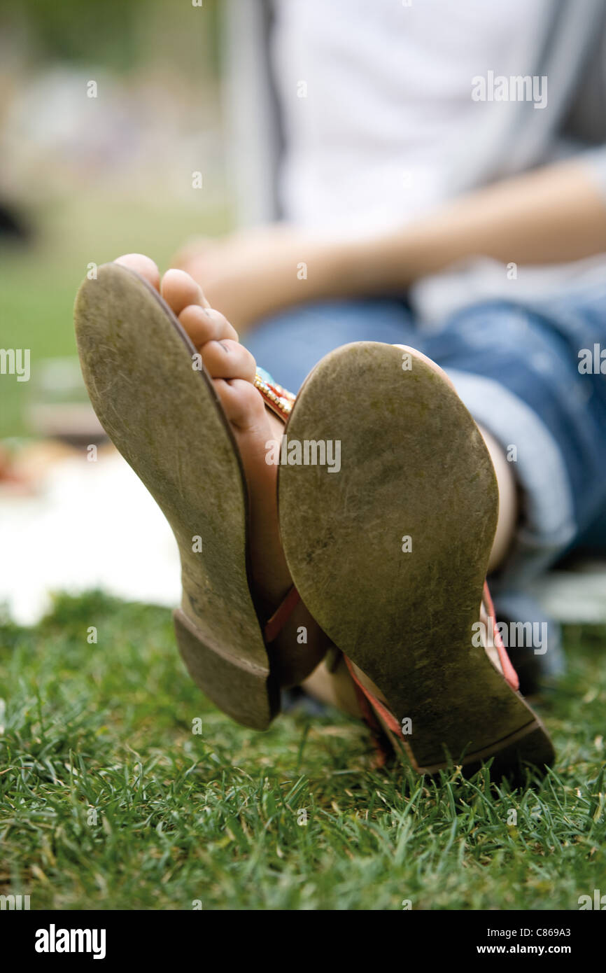 Woman sitting in grass with legs crossed at ankle, cropped Stock Photo ...