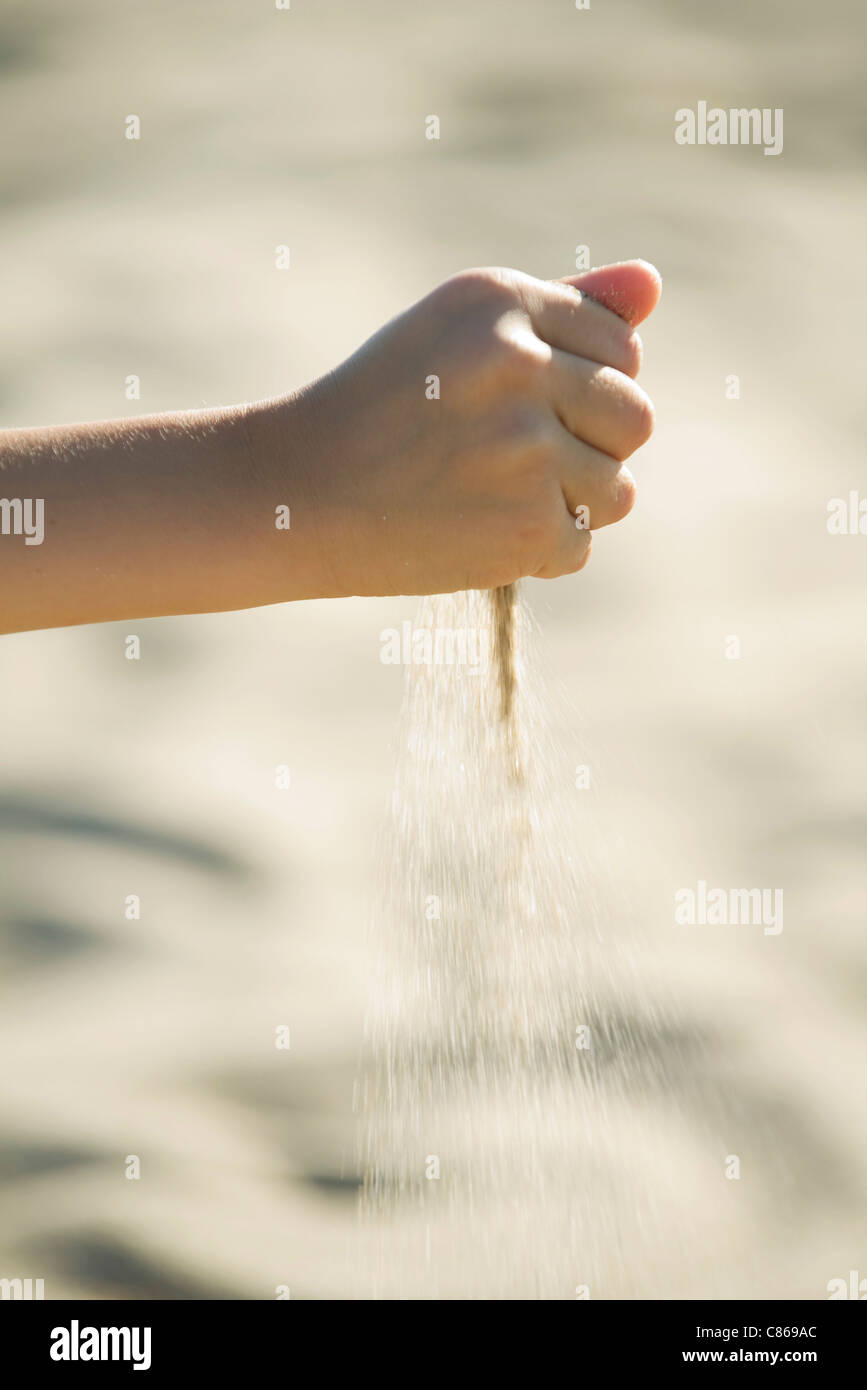 Sand spilling from child's hand Stock Photo - Alamy