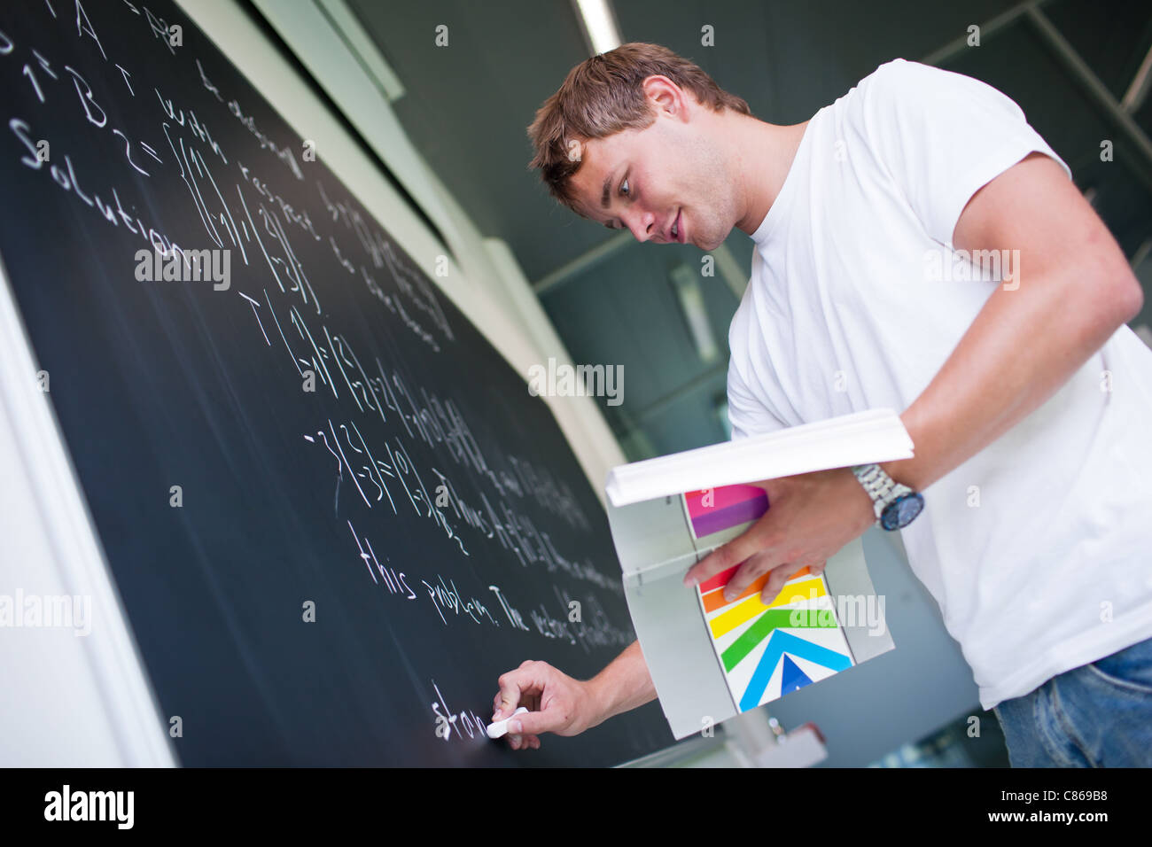 Handsome male college student writing on blackboard/chalkboard (color ...