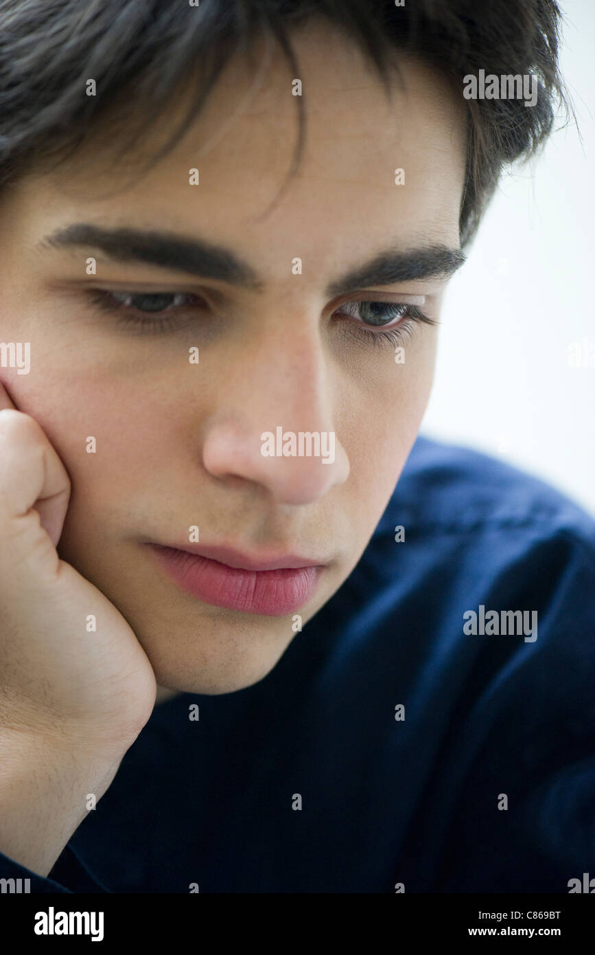 Young man looking down in thought, portrait Stock Photo - Alamy