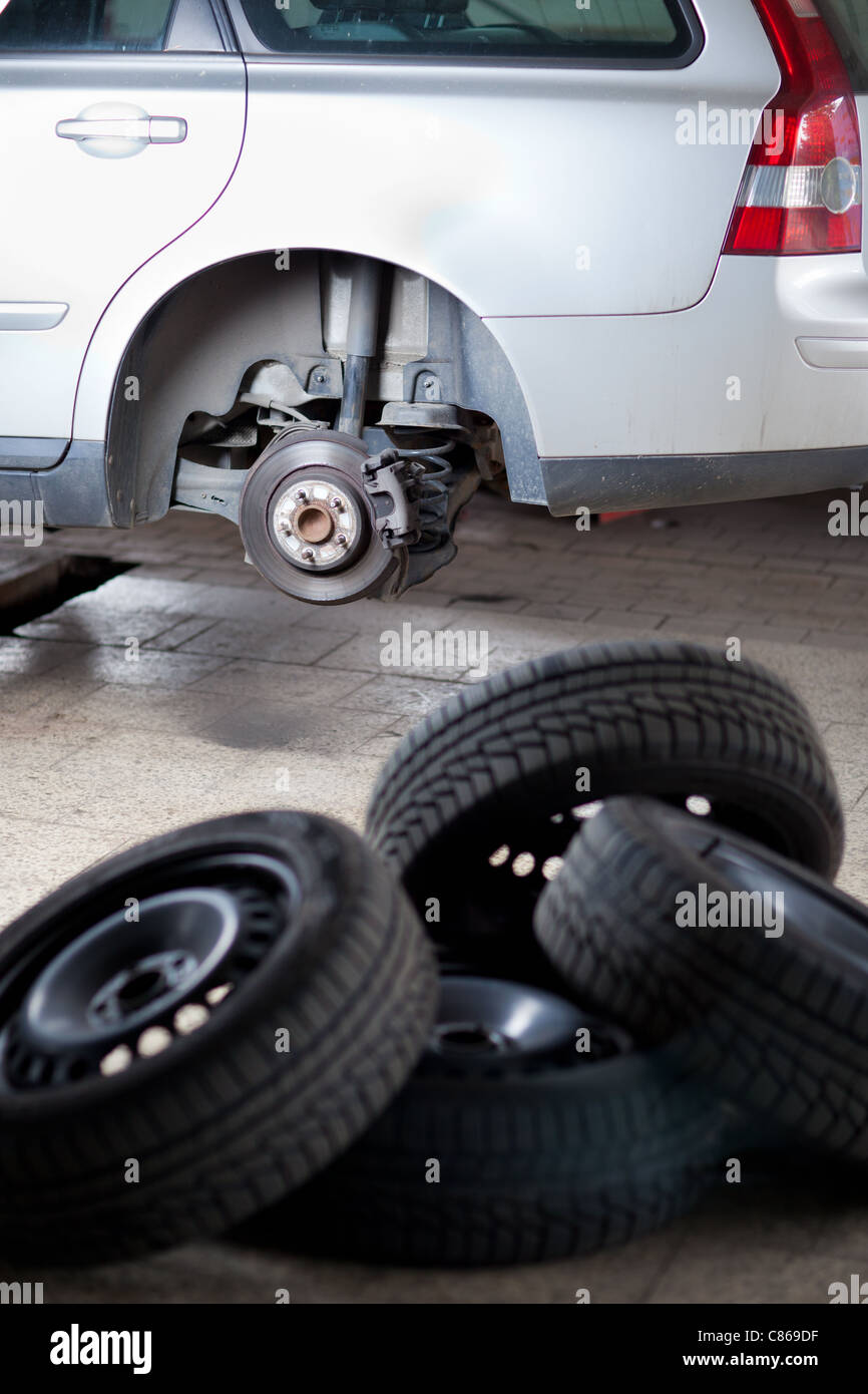 mechanic changing a wheel of a modern car (shallow DOF; color toned ...
