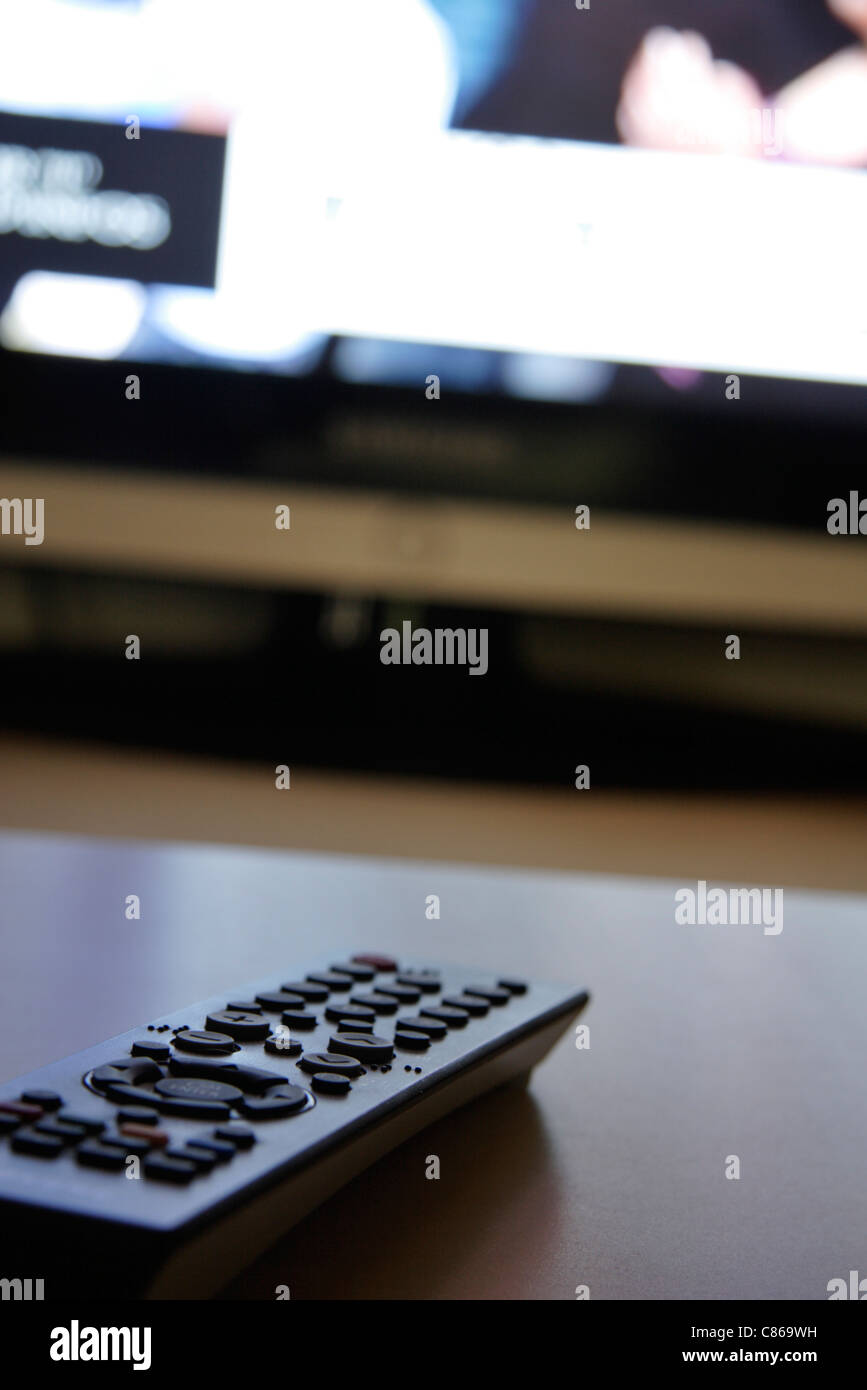 Remote control, television screen in background Stock Photo - Alamy